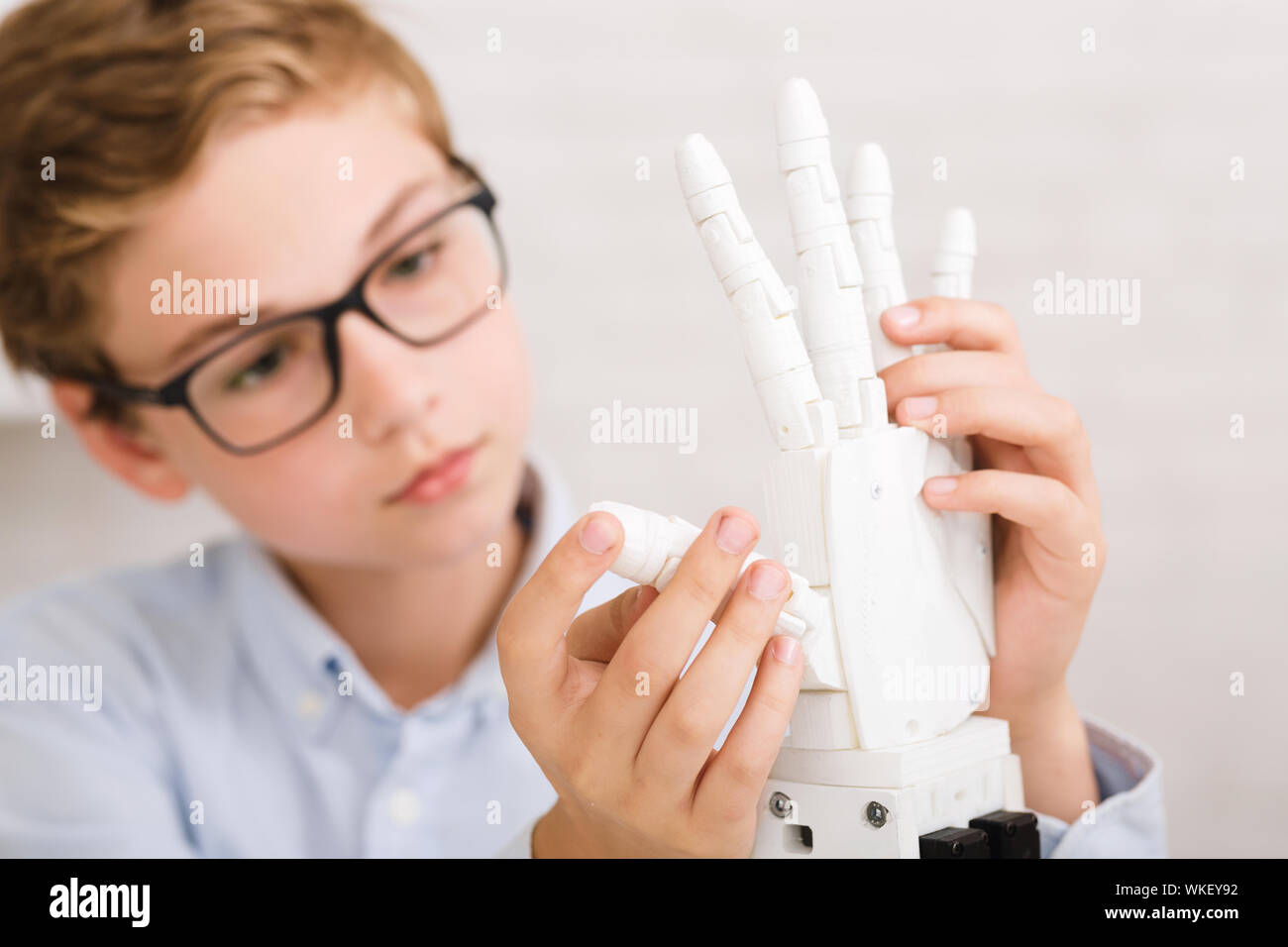 Smart schoolboy experimenting with humanoid robotic hand Stock Photo ...