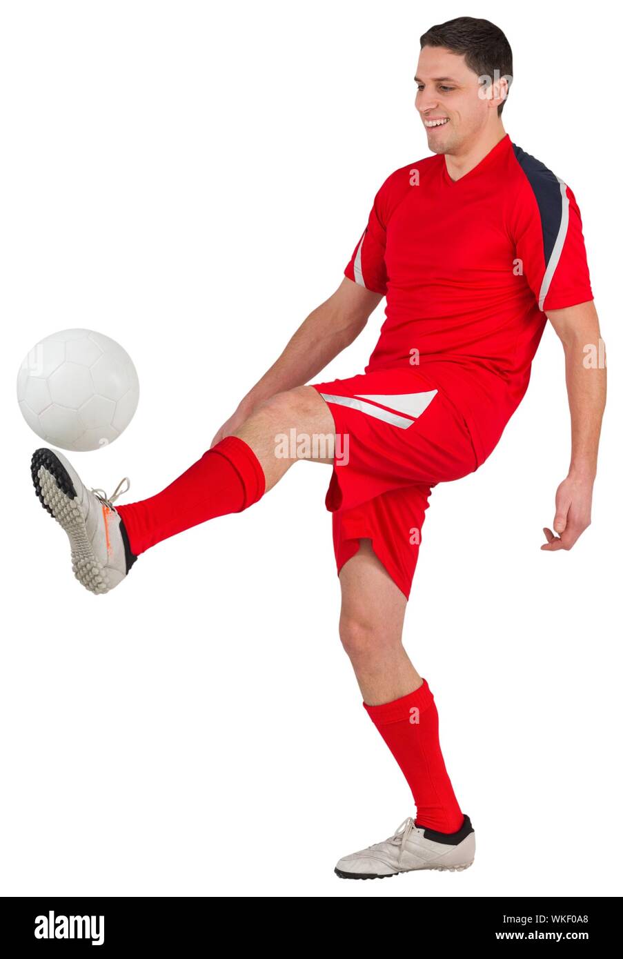 Fit young football player kicking on white background Stock Photo - Alamy