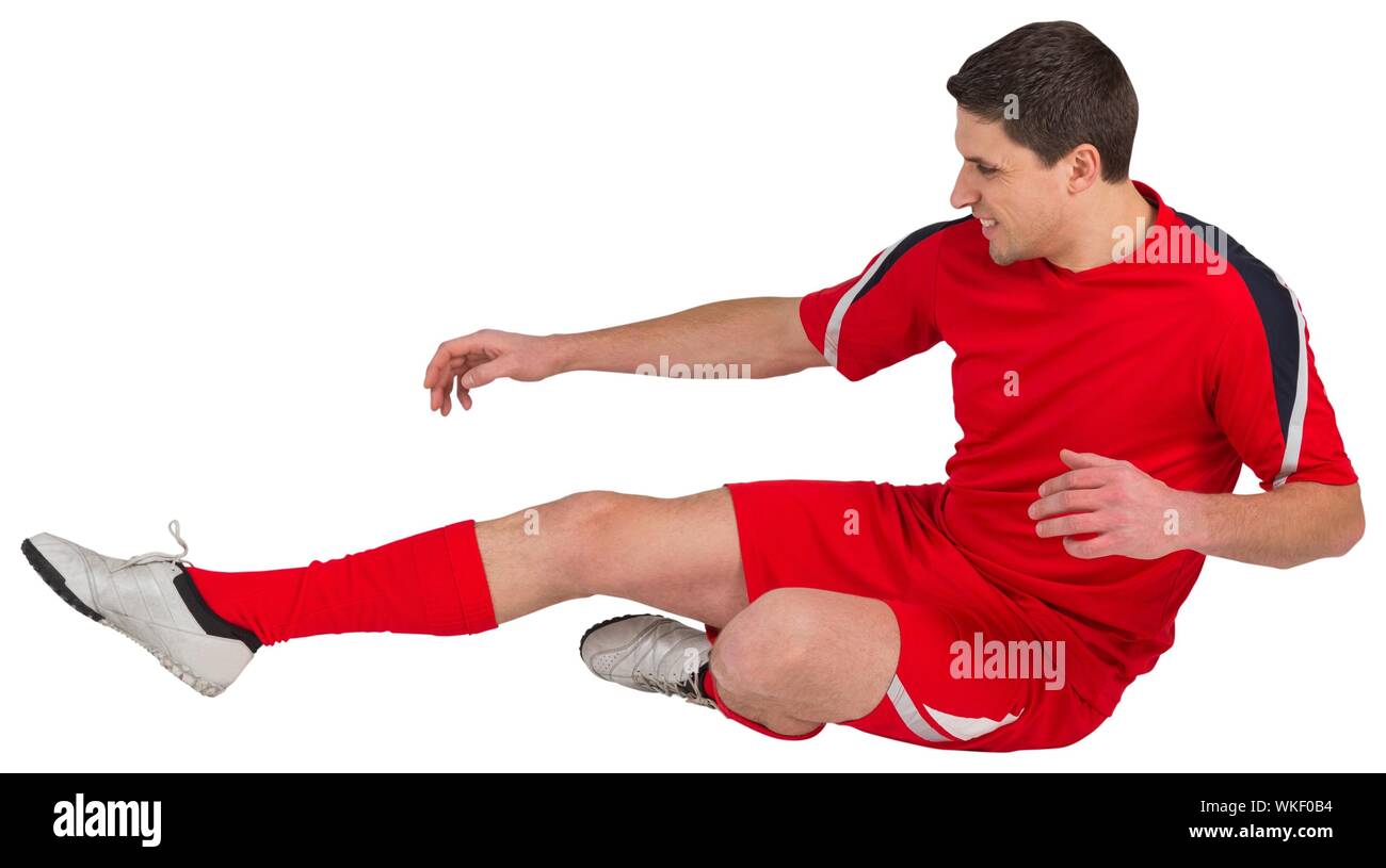 Fit football player jumping and kicking on white background Stock Photo ...
