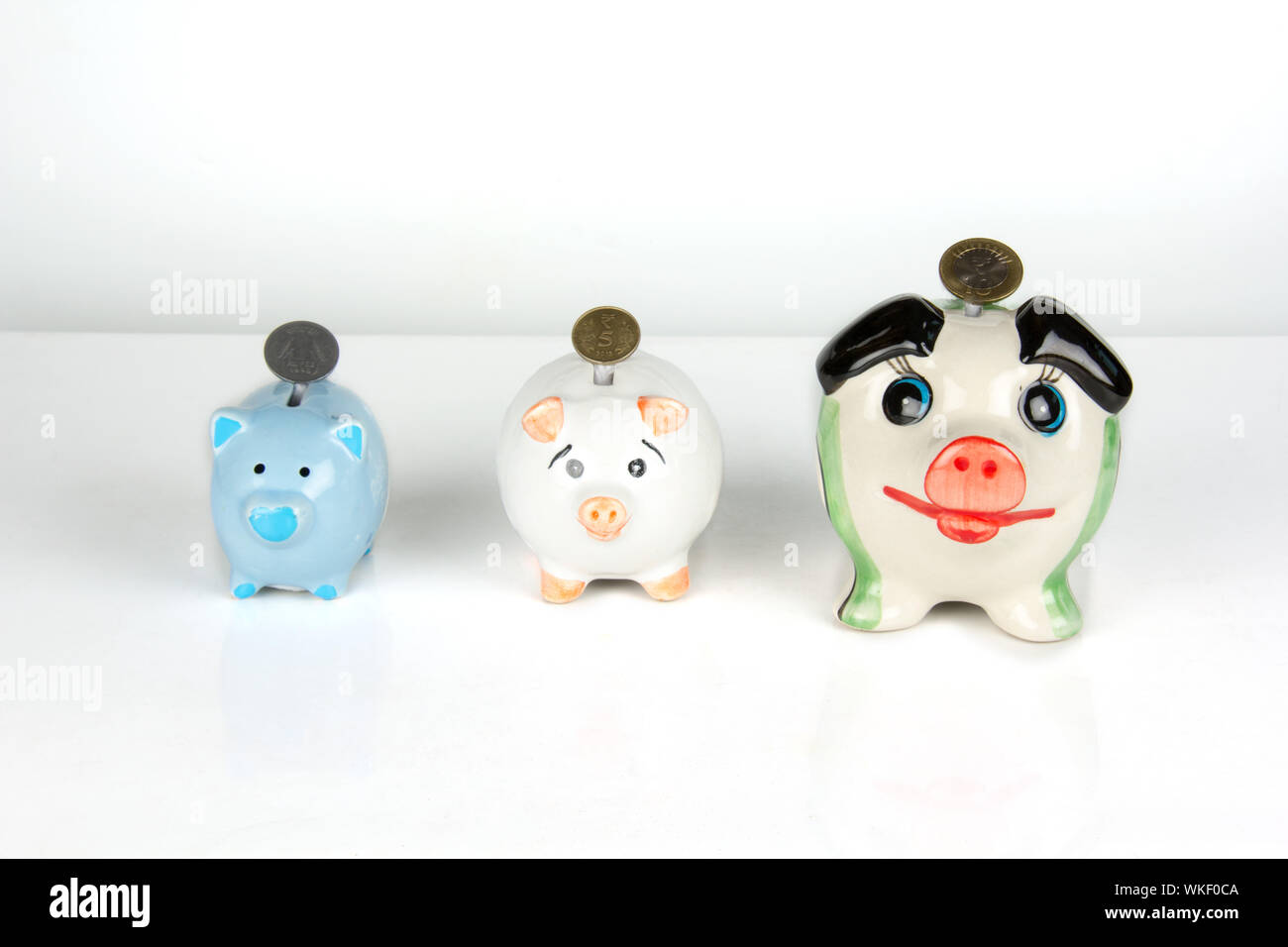 Coins on piggy banks Stock Photo - Alamy