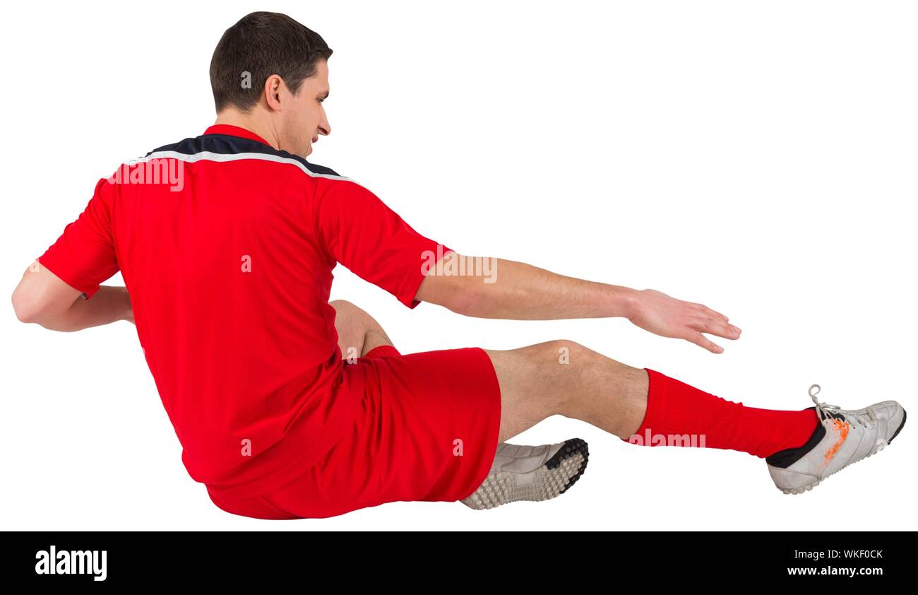Fit football player jumping and kicking on white background Stock Photo ...