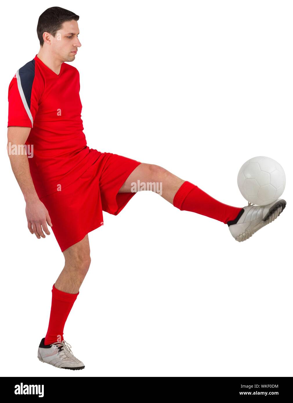 Fit young football player kicking on white background Stock Photo - Alamy