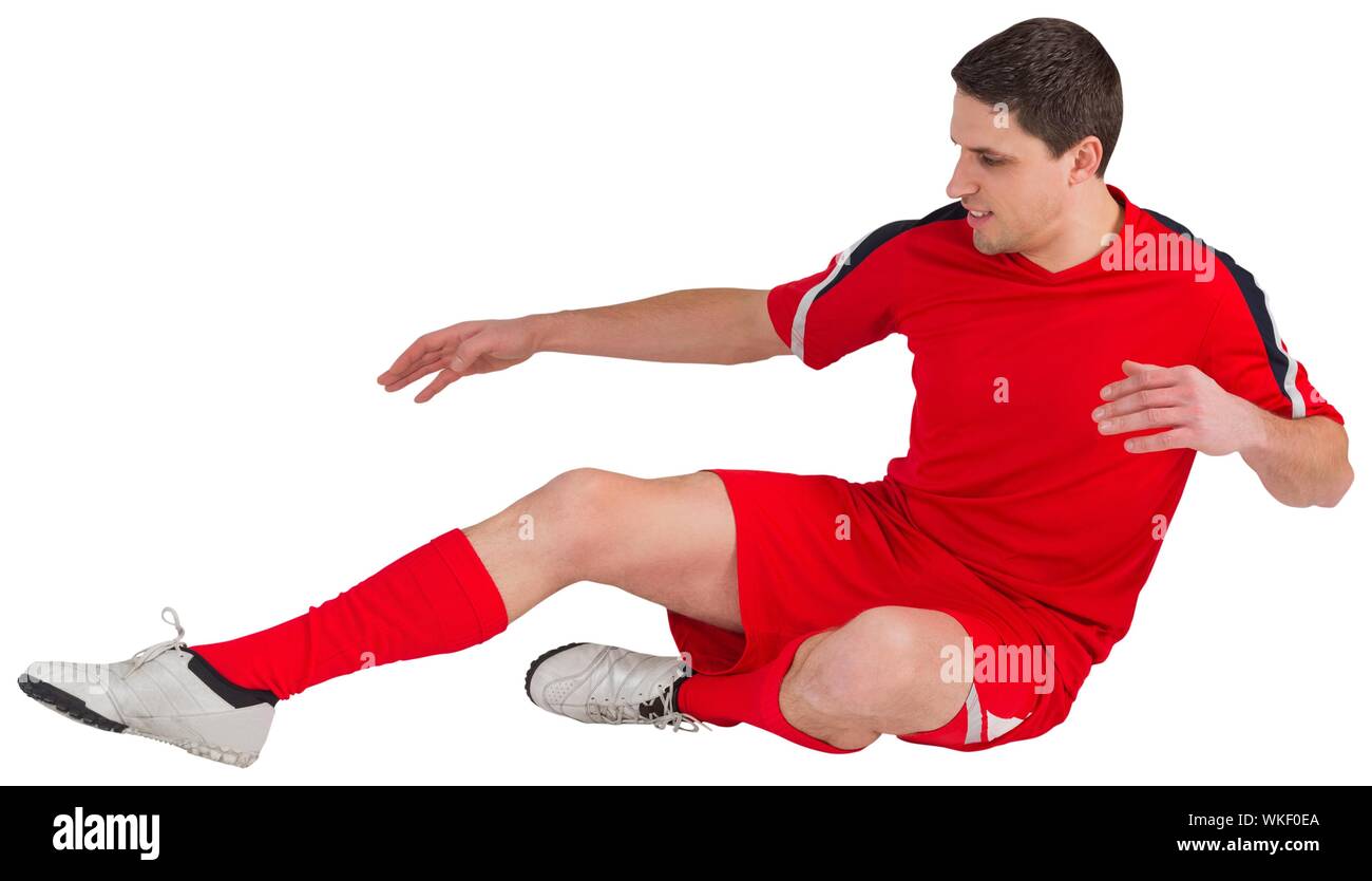 Fit football player jumping and kicking on white background Stock Photo ...