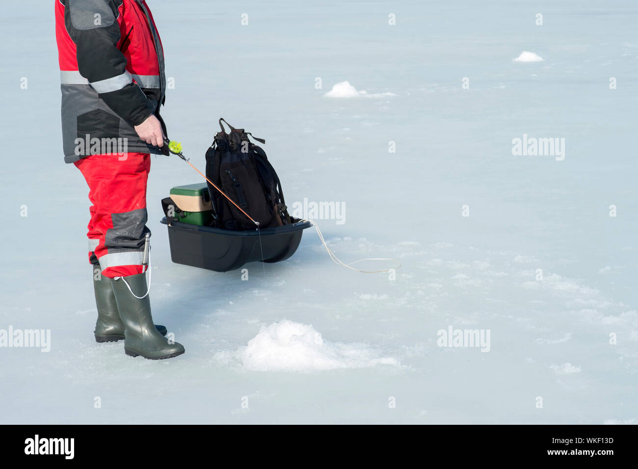 Legs of a male fisherman close-up in a bright jumpsuit that produces a ...