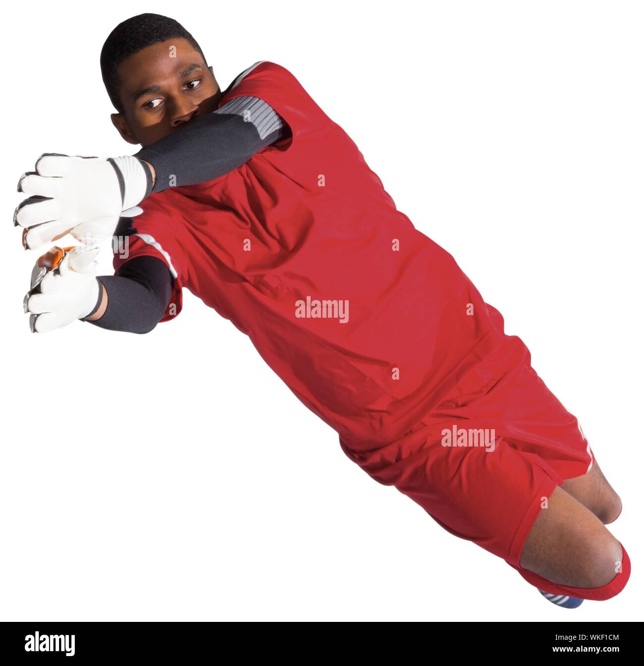 Goalkeeper in red making a save on white background Stock Photo - Alamy