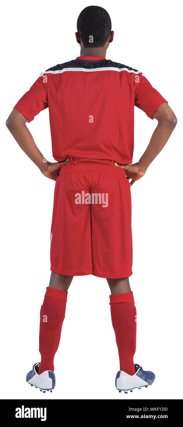 Football player in red standing on white background Stock Photo - Alamy