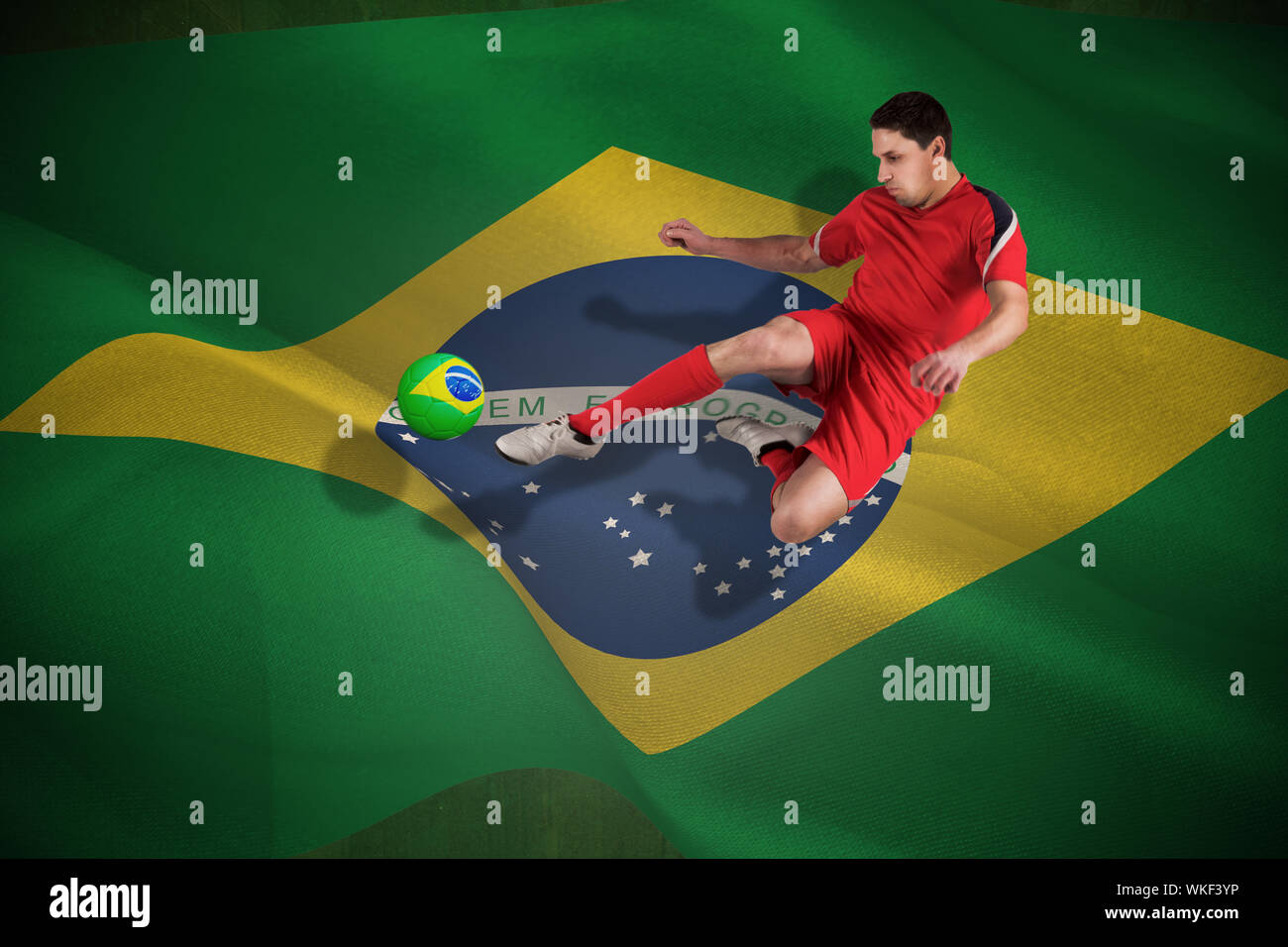 Fit football player jumping and kicking against white leather football ...