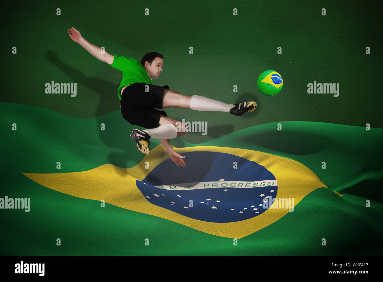 Football player in green kicking against white leather football with ...