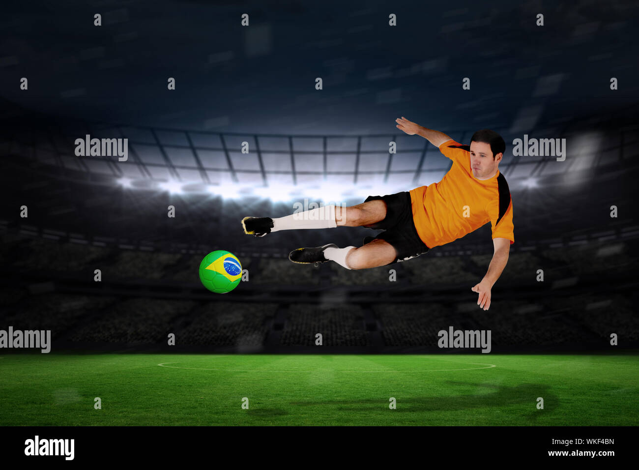 Football player in orange jumping against large football stadium with ...