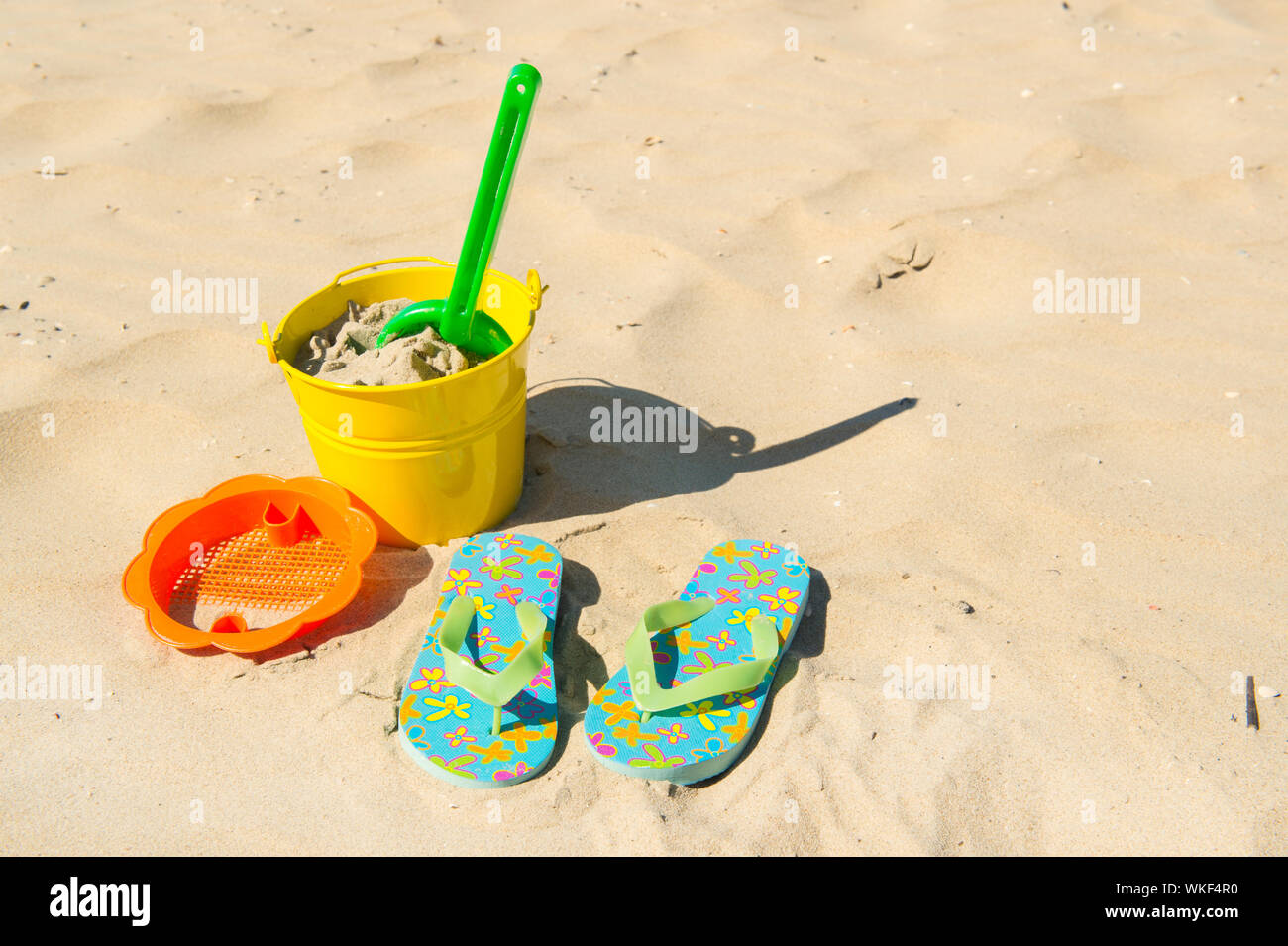 Yellow bucket and other toys at the beach Stock Photo - Alamy