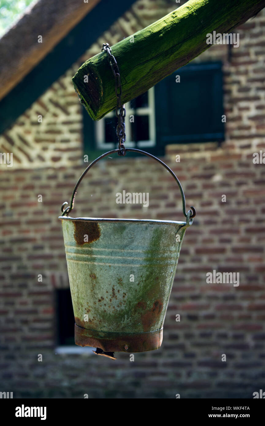 Rusty water bucket as weight for pump Stock Photo - Alamy