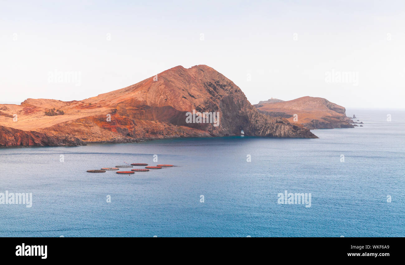 Coastal landscape with fish farm and red rocks of Ponta de Sao Lourenco ...