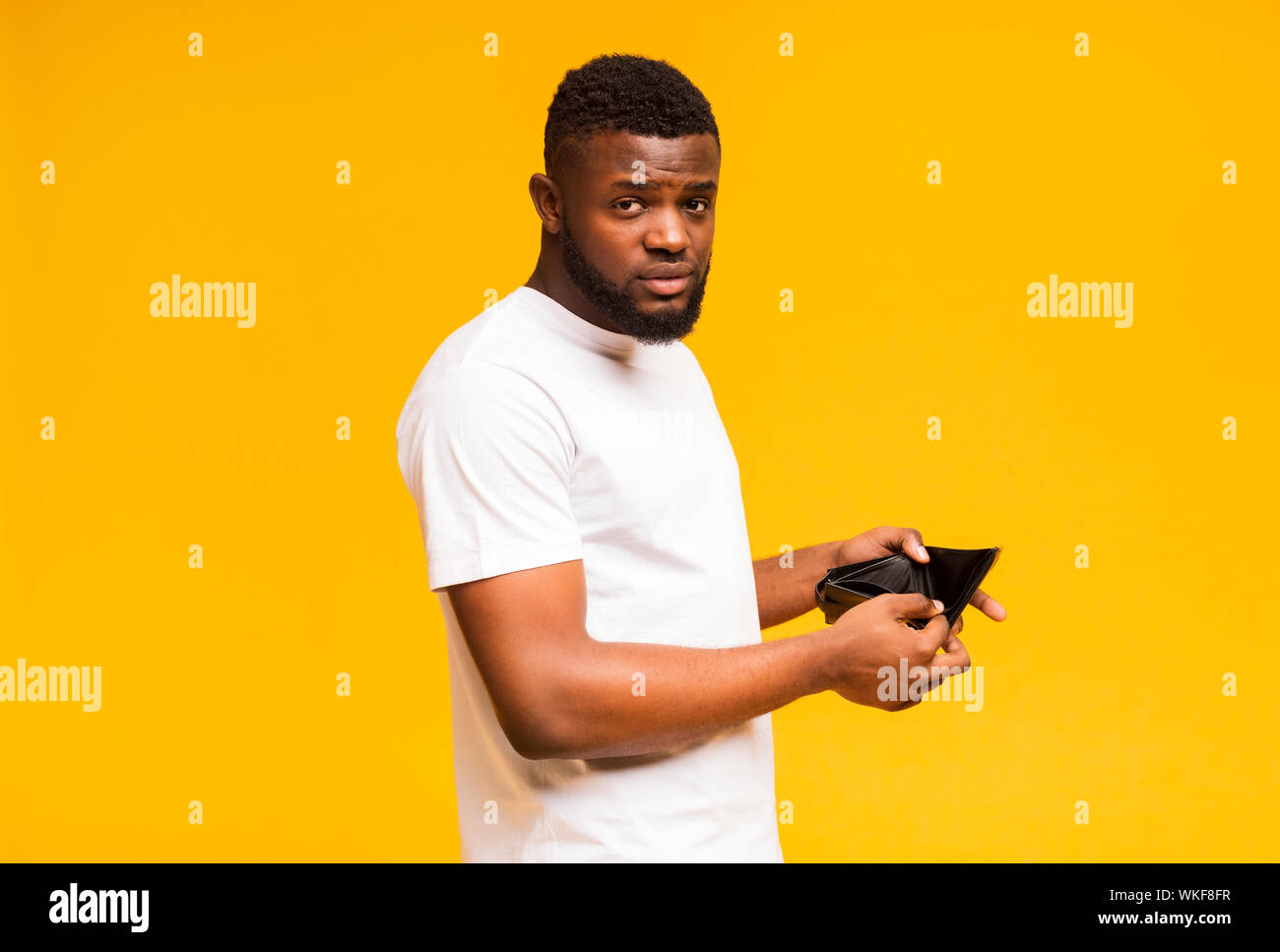 Sad african american man showing empty wallet Stock Photo - Alamy