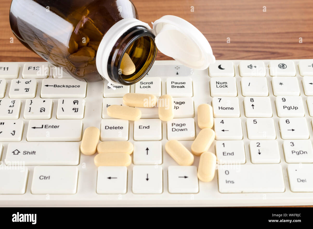 pills on keyboard computer on wooden background concept technology ...