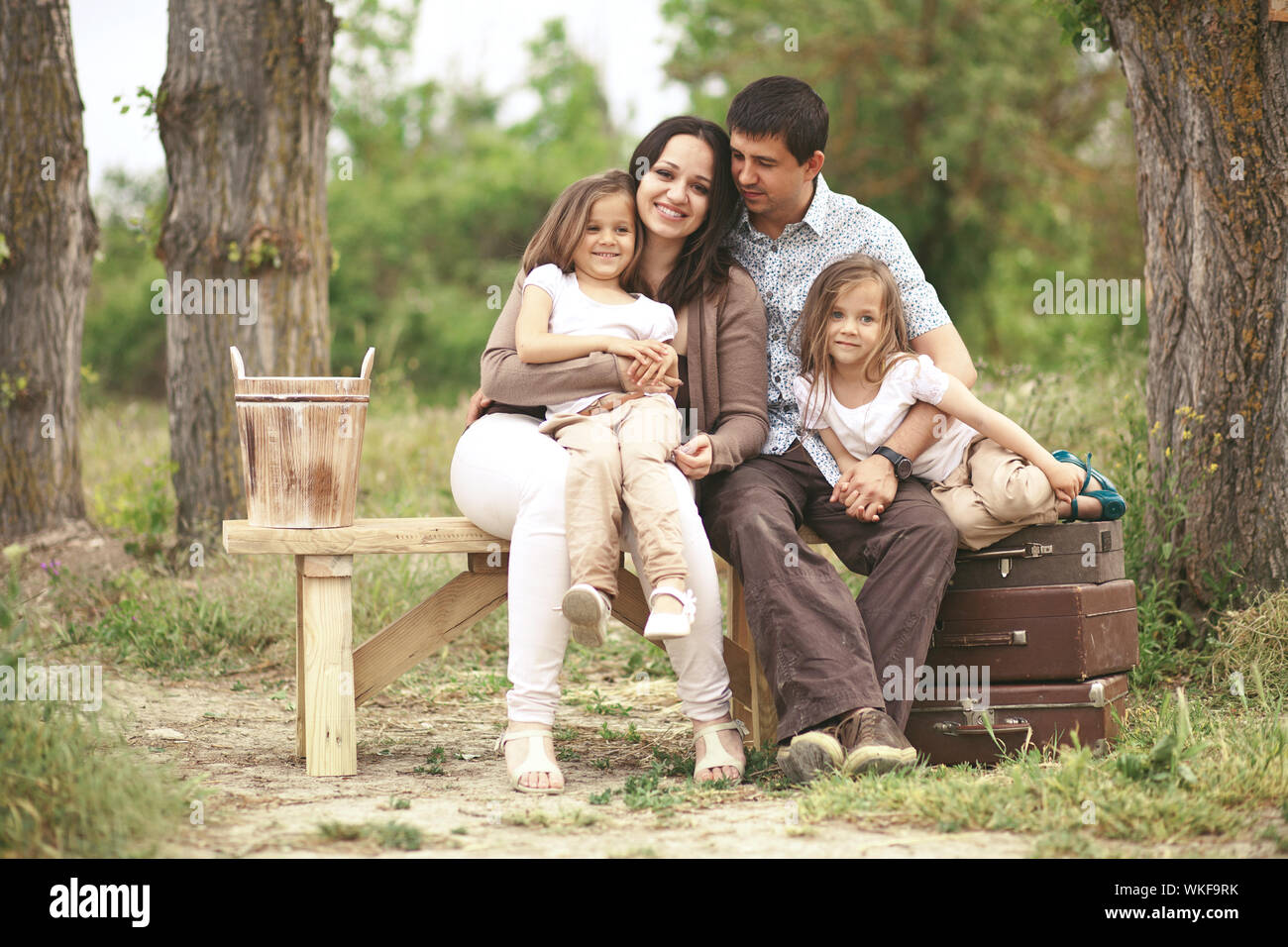Family portrait outdoor on wooden bench in rustic style Stock Photo - Alamy