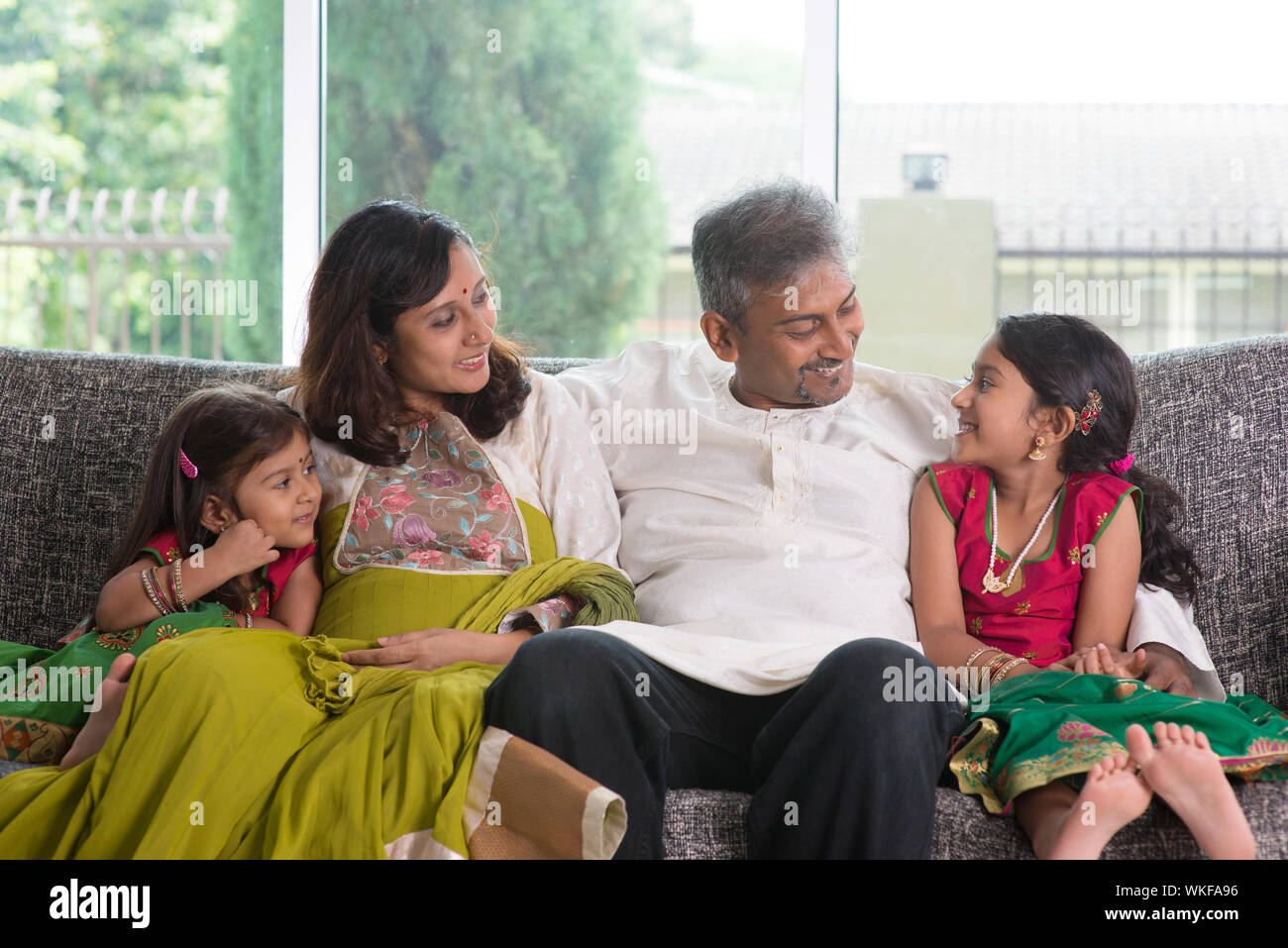 Happy Indian family at home. Asian parents chit chatting with their ...