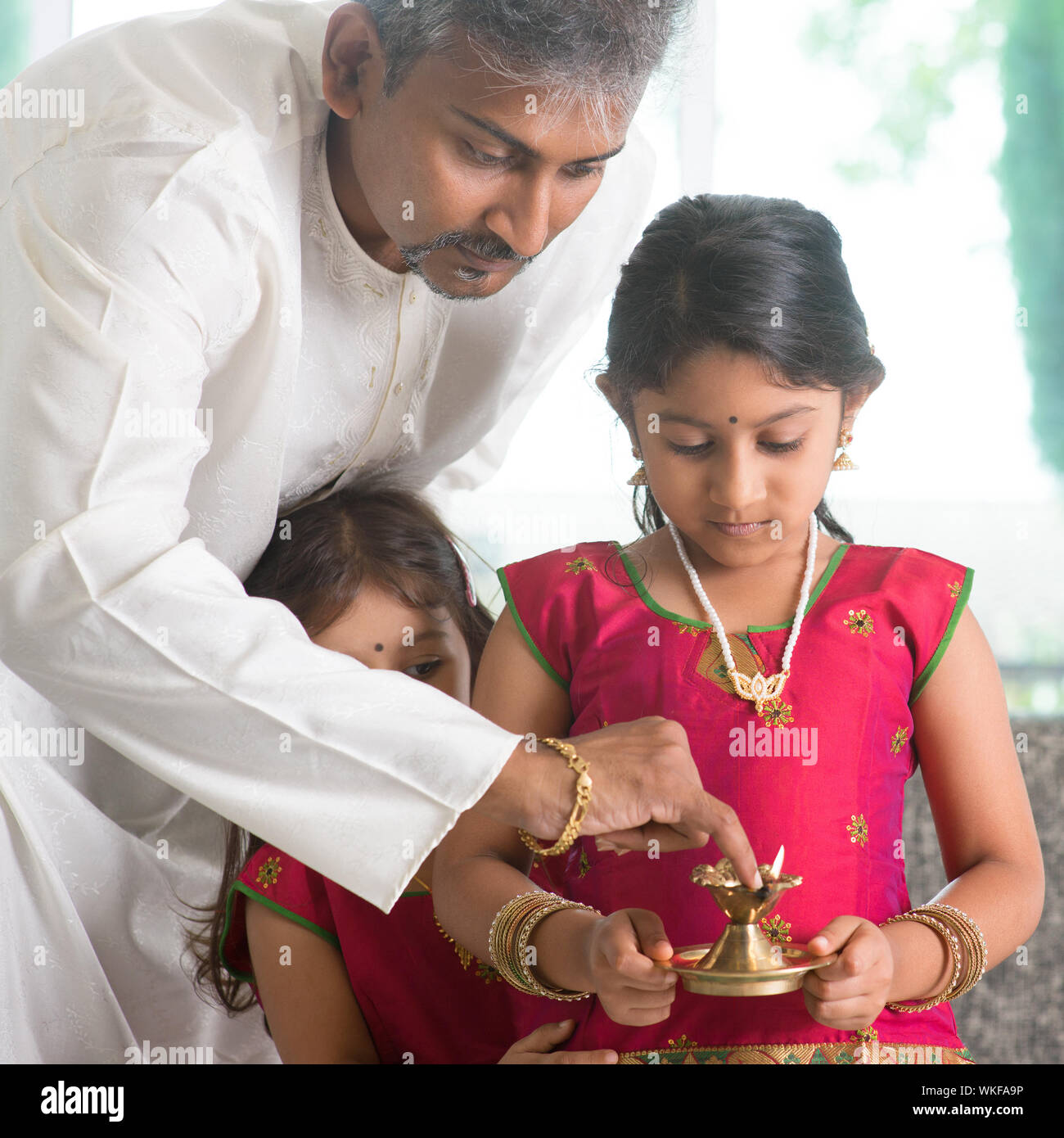 Indian family in traditional sari preparing to celebrate diwali or ...