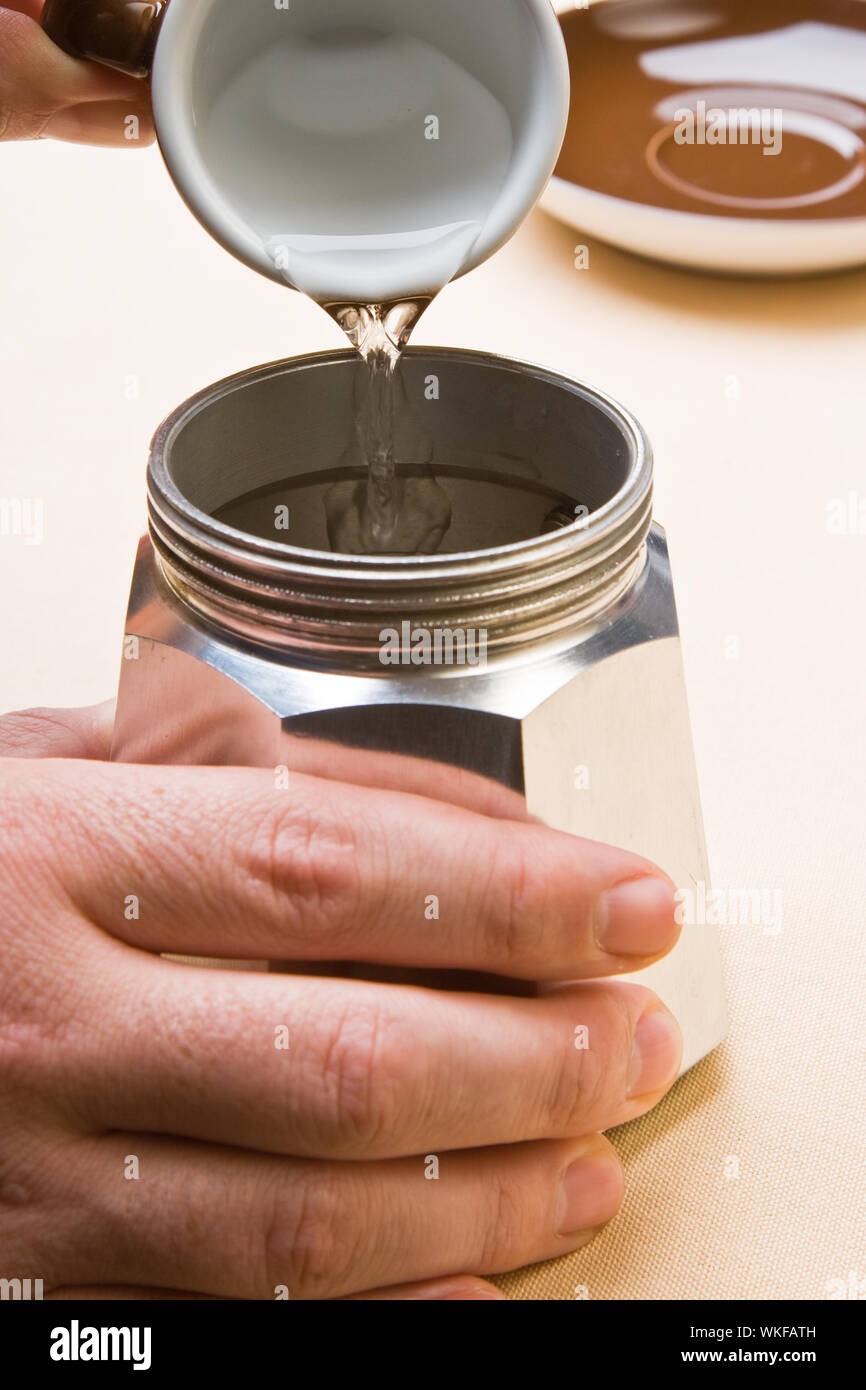 Pouring the water into the can Stock Photo - Alamy