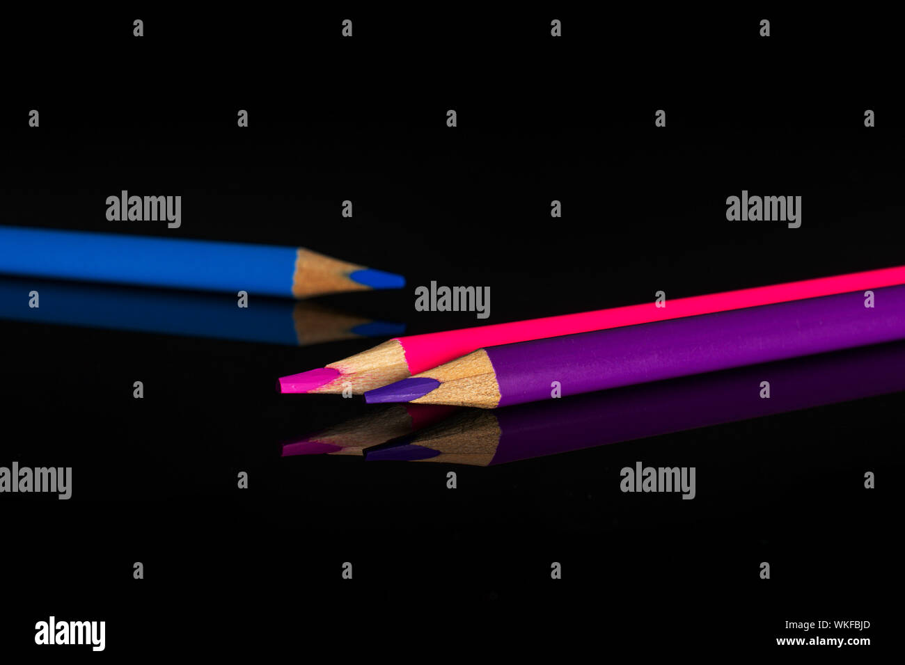Group of three whole sharp colored pencil isolated on black glass Stock ...