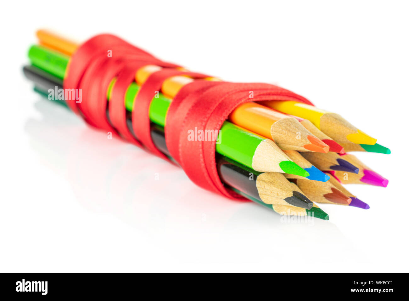 Lot of whole colored pencil tied by red ribbon isolated on white ...
