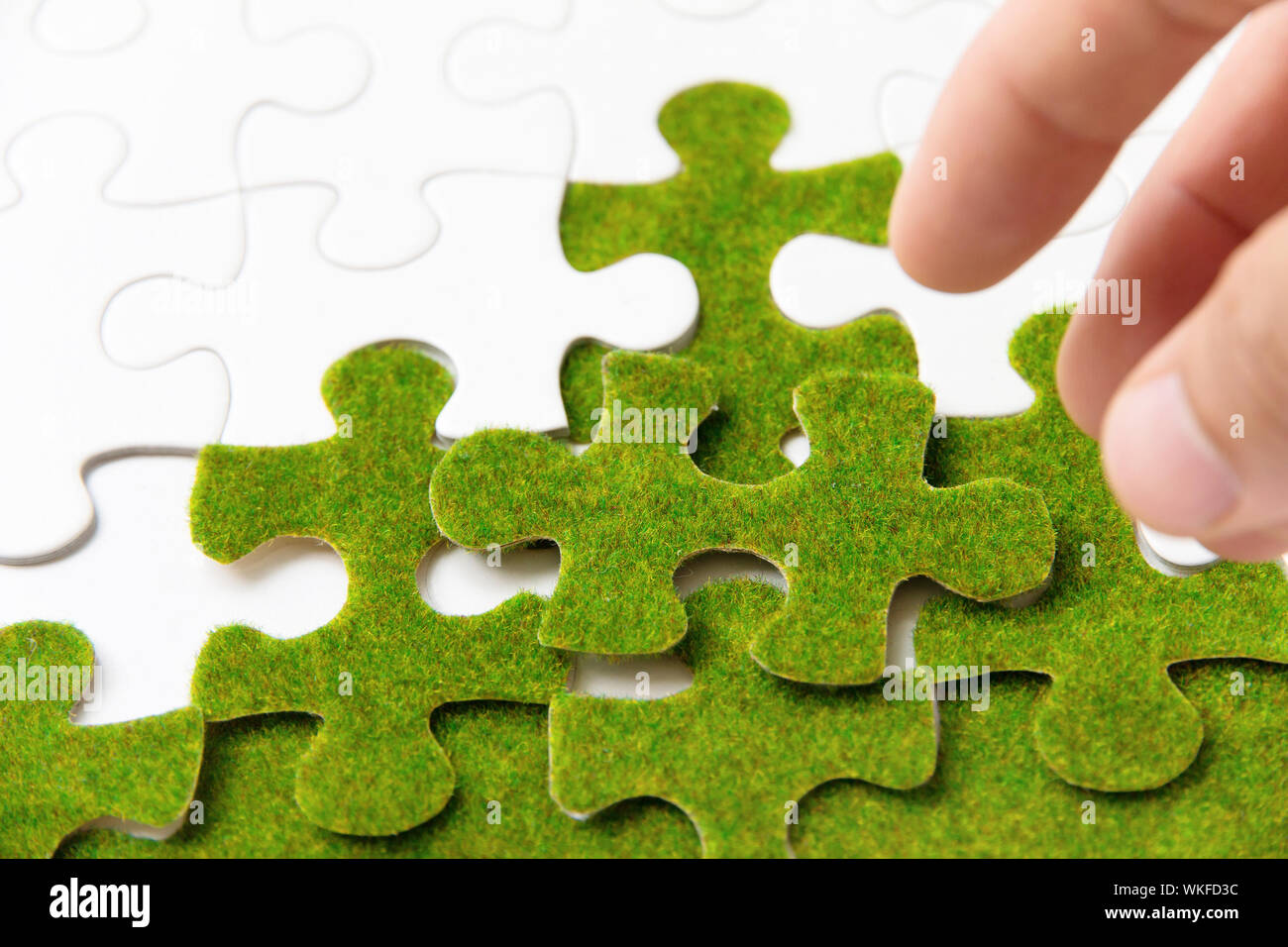 hand holding a green puzzle piece Stock Photo - Alamy