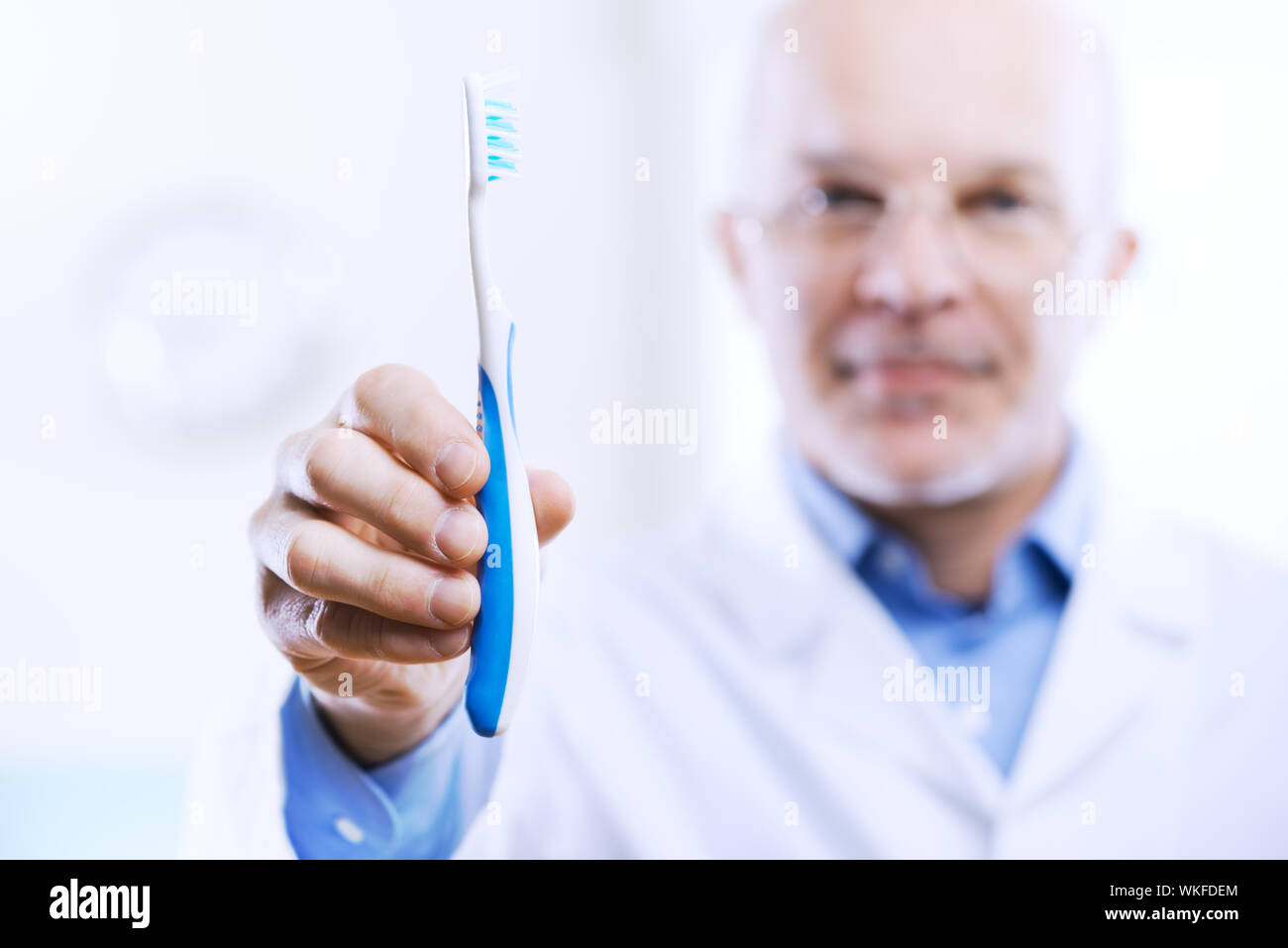 Dentist showing a tootbrush, dental hygiene and prevention concept ...