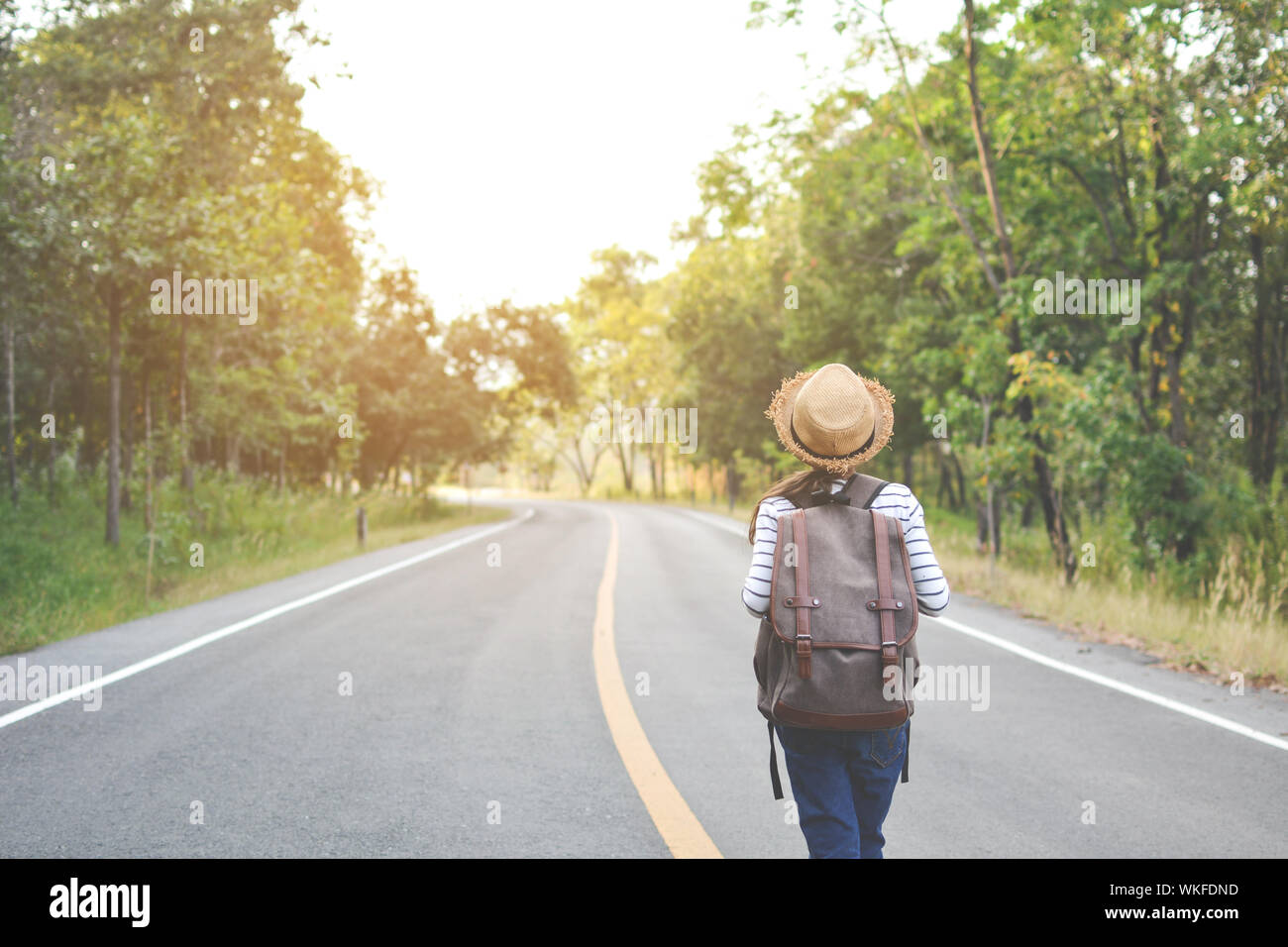 Woman walking rear view road hi-res stock photography and images - Alamy