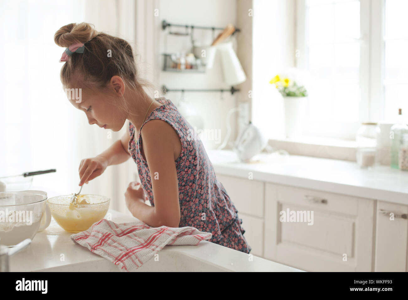 7 years old school girl cooking at the kitchen, casual lifestyle photo ...