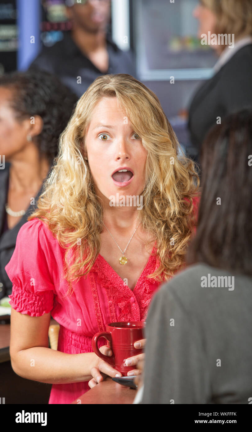 Shocked young lady in cafe with friend Stock Photo - Alamy