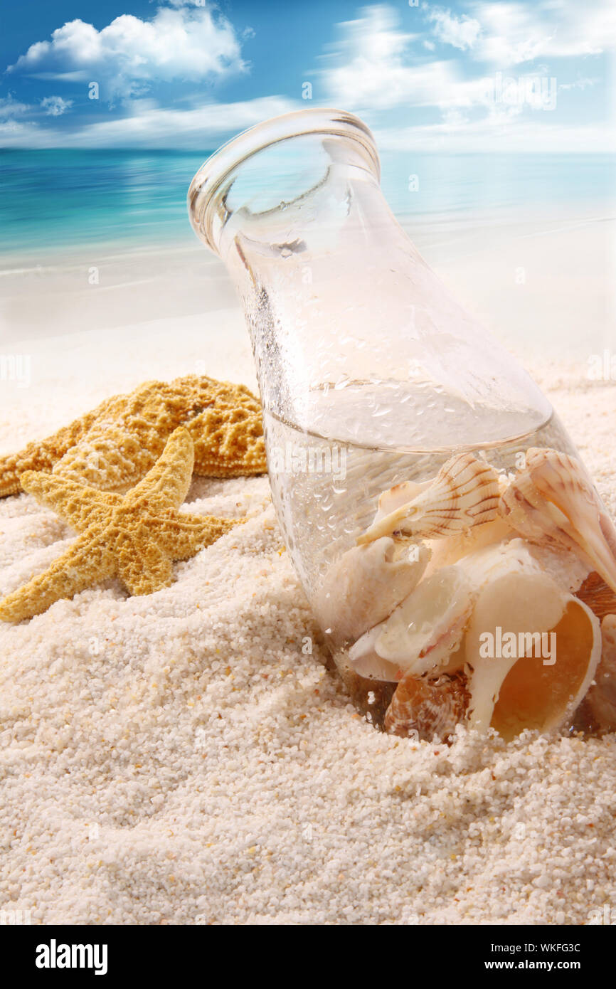 Bottle with shells on the beach Stock Photo - Alamy