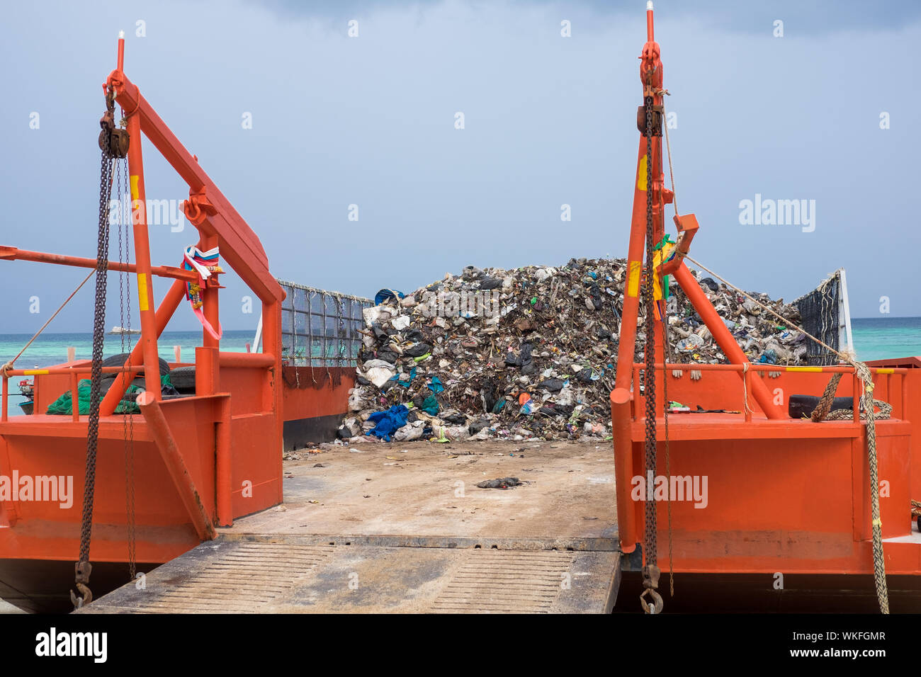 Boat collecting trash from the ocean beach in Thailand Stock Photo - Alamy