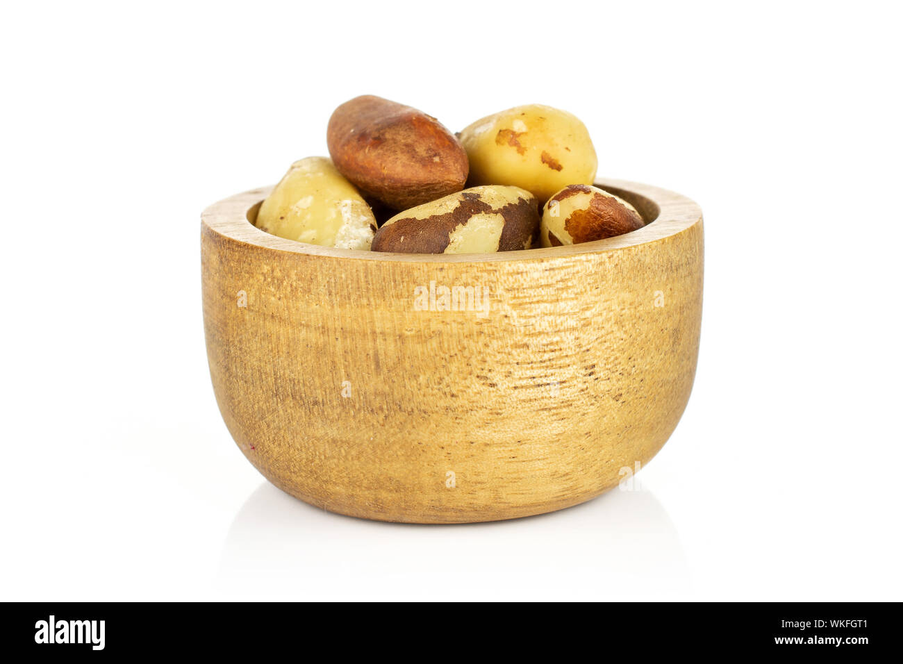Lot of whole raw brown brazil nut in tiny wooden bowl isolated on white ...