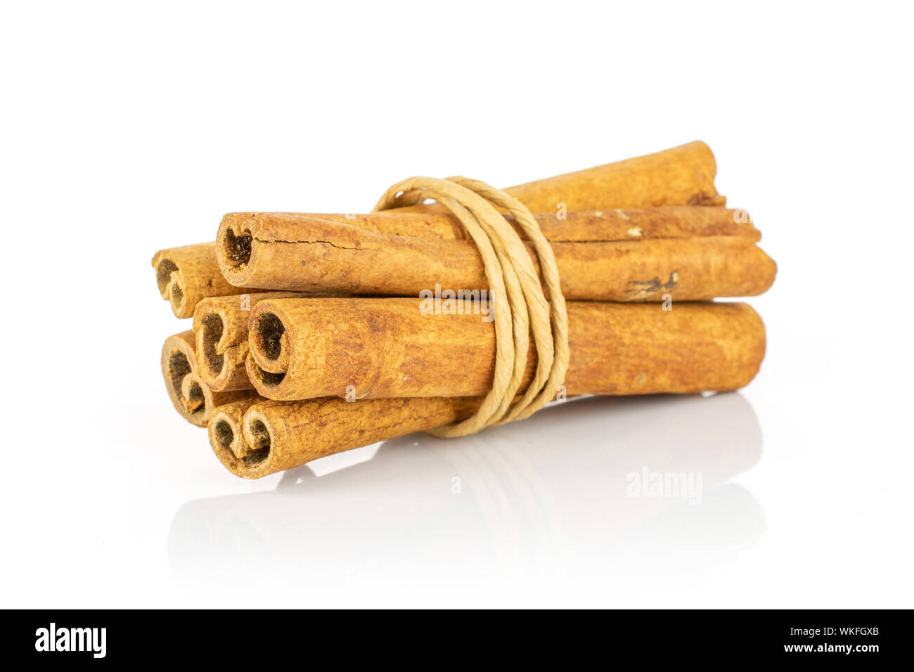 Group of six whole dry brown cinnamon wrapped in natural twine isolated ...
