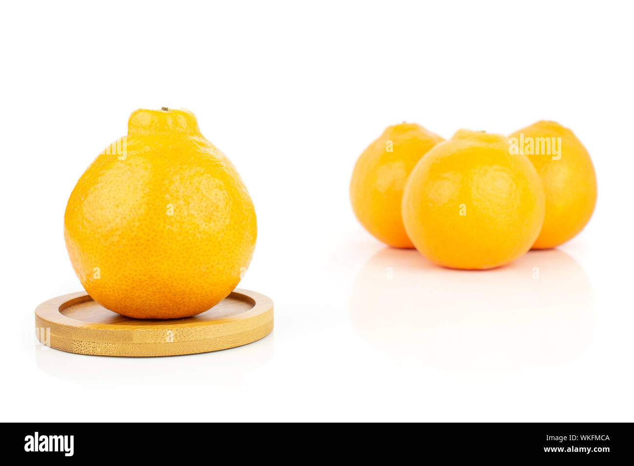 Group of four whole fresh orange tangelo minneola on round bamboo ...