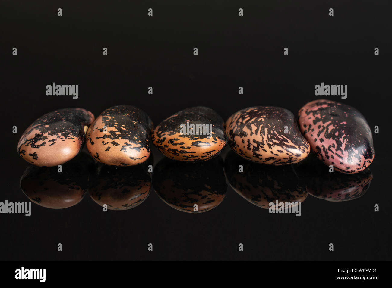 Group of five whole stained purple bean isolated on black glass Stock ...