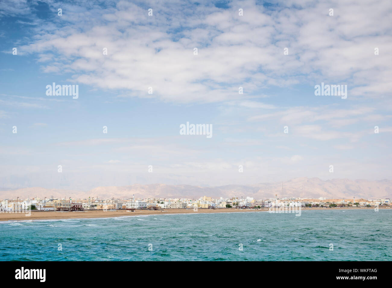 Image of a view to Sur in Oman with sea, mountains, houses and sky ...