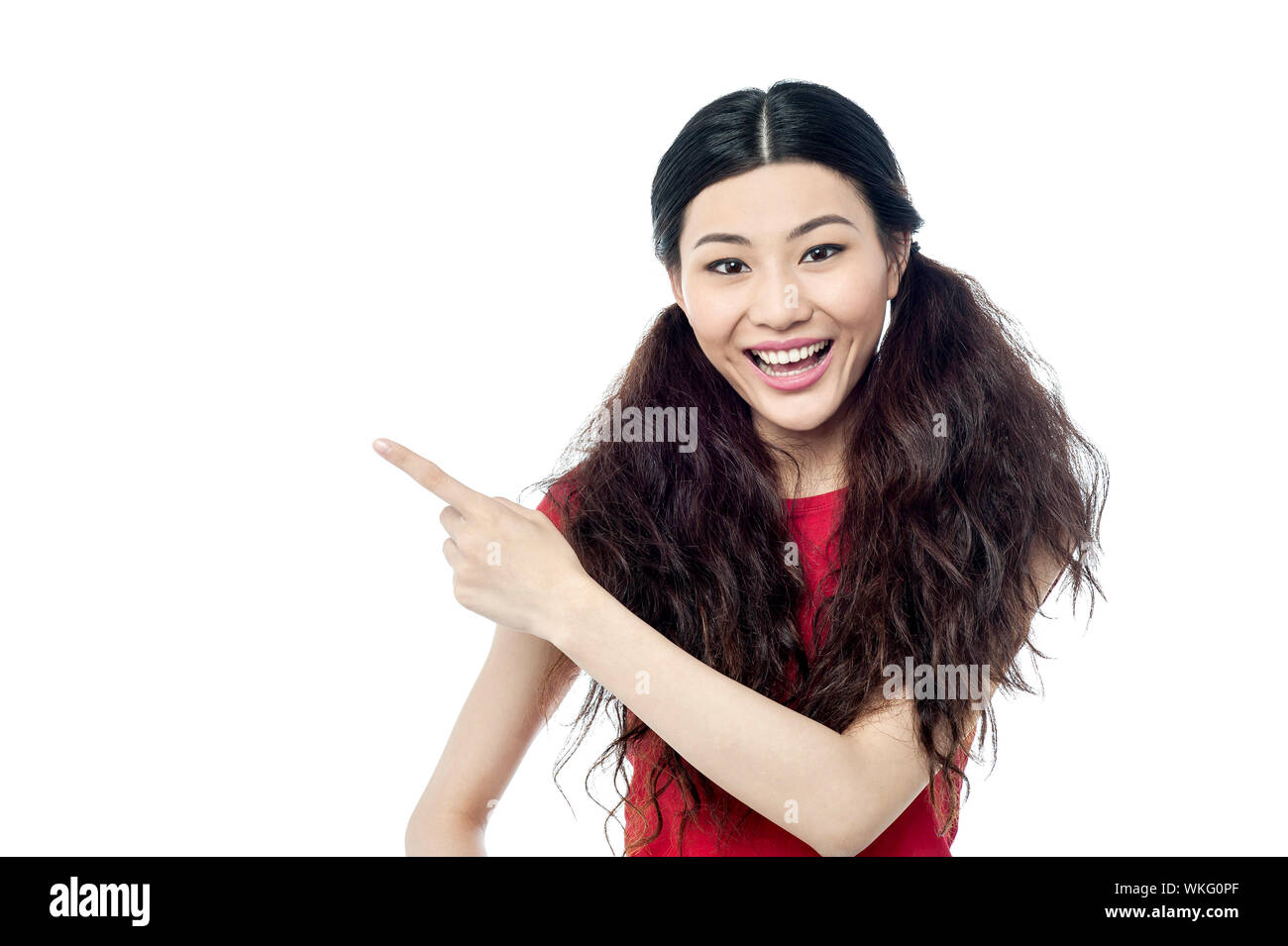 Pretty girl pointing towards something Stock Photo - Alamy
