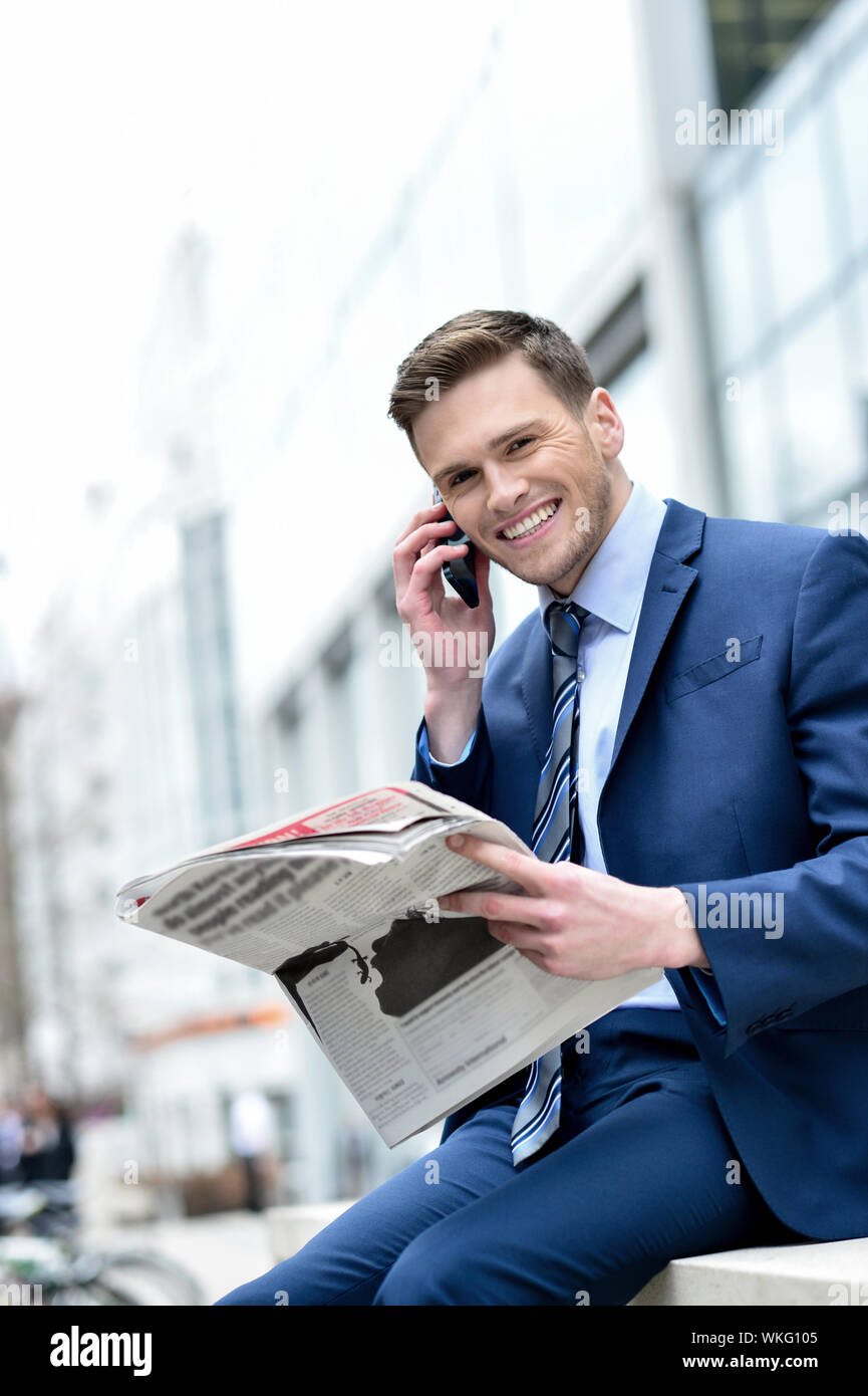 Guy communicating while reading newspaper Stock Photo - Alamy