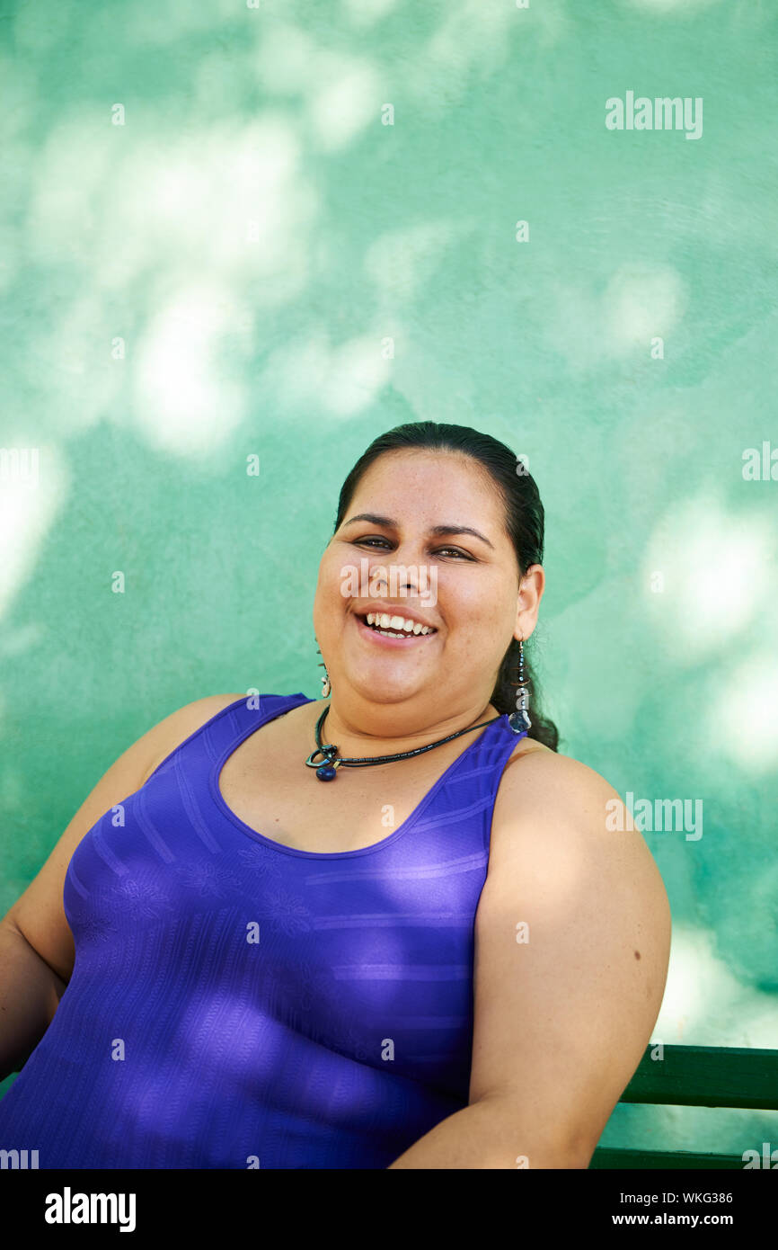 Portrait of overweight hispanic woman looking at camera and smiling ...