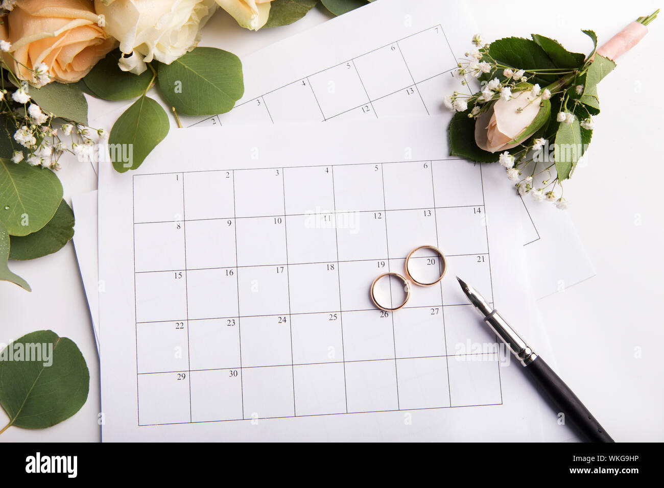 Wedding rings choosing the date in paper calendar Stock Photo - Alamy