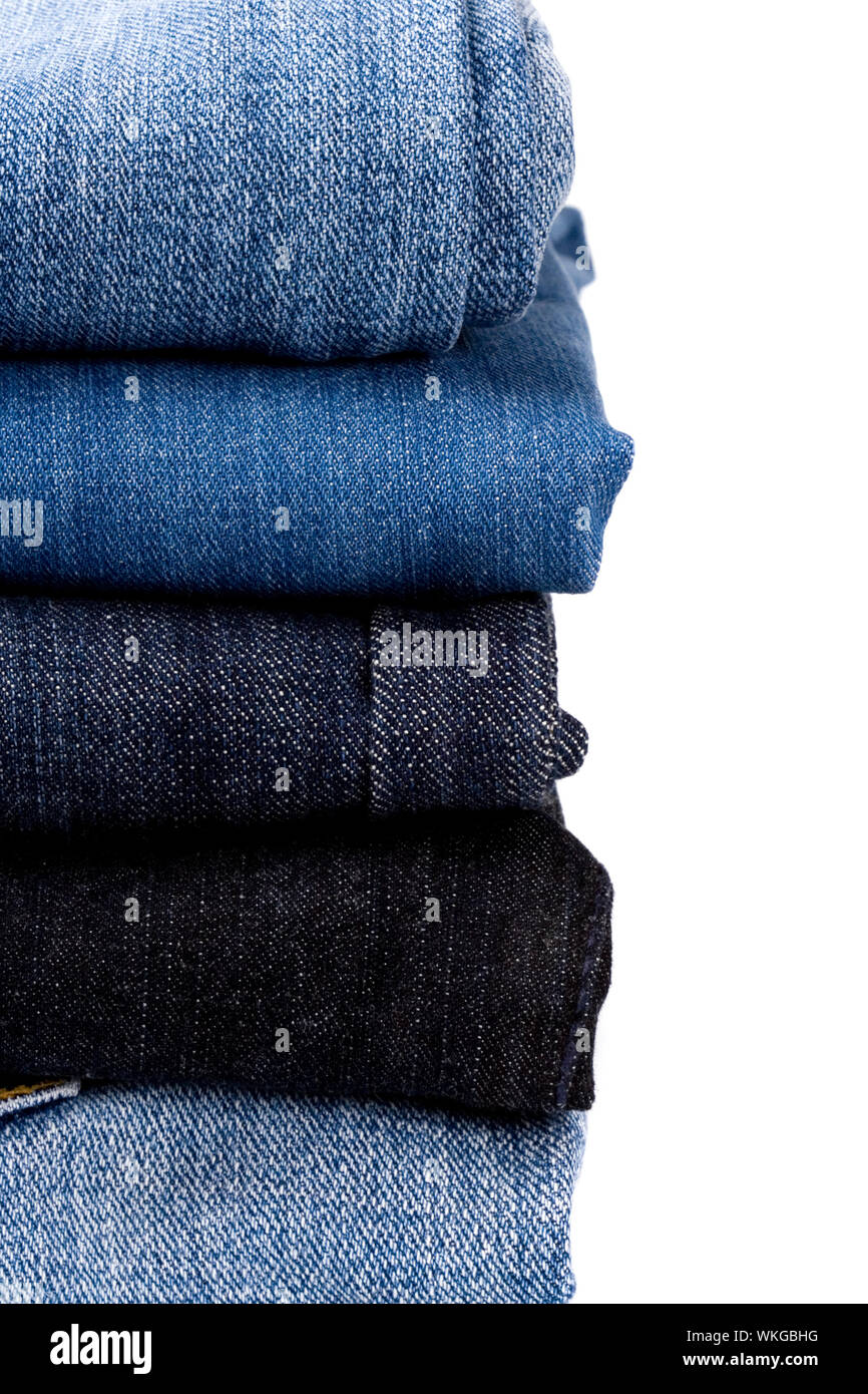 stack of blue jeans closeup on white background Stock Photo - Alamy