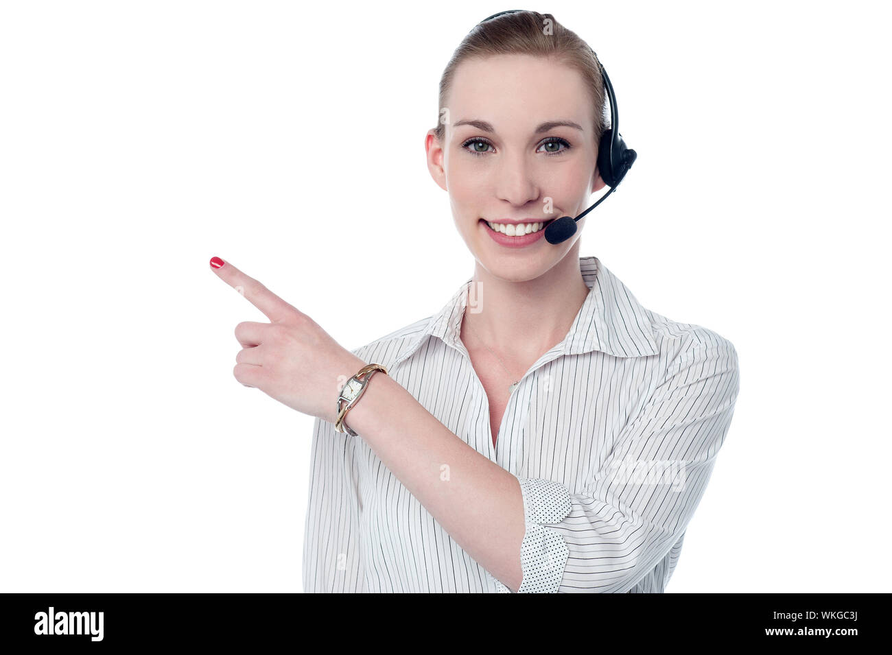 Happy customer support executive in headset pointing away Stock Photo ...