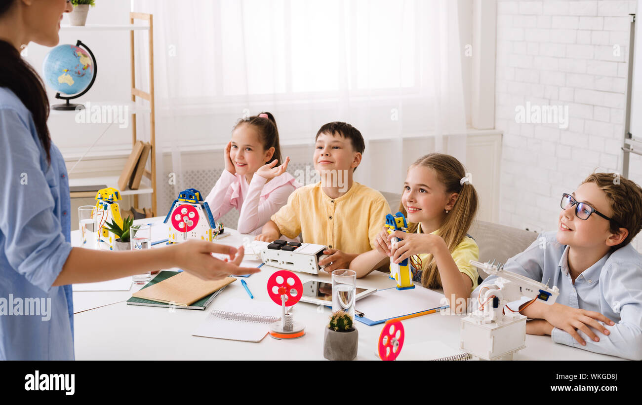 Teacher explaining new material to children, kids creating robots Stock ...