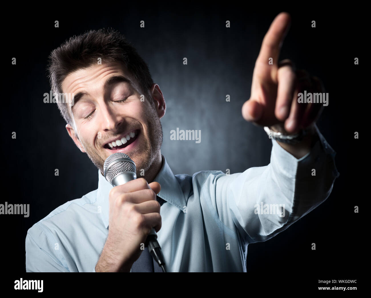 Man giving a speech with microphone and gesturing Stock Photo - Alamy