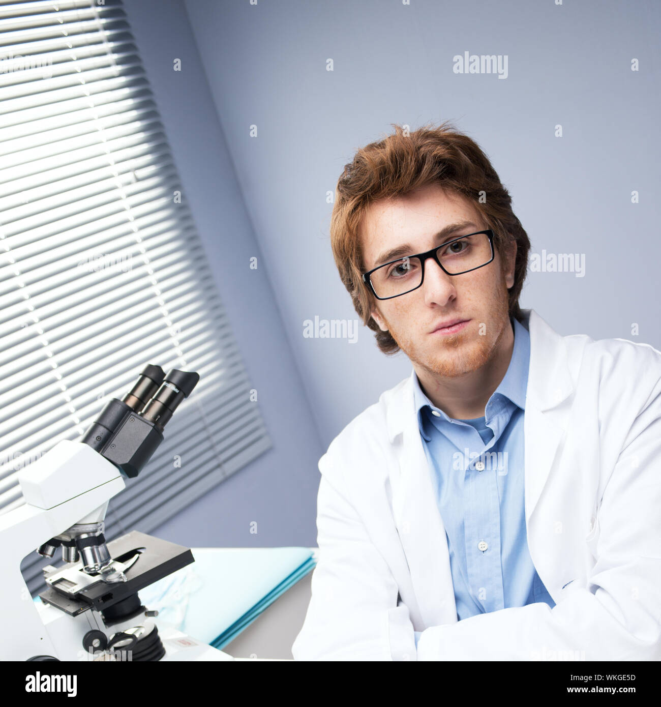 Student researcher at desk with microscope on background Stock Photo ...
