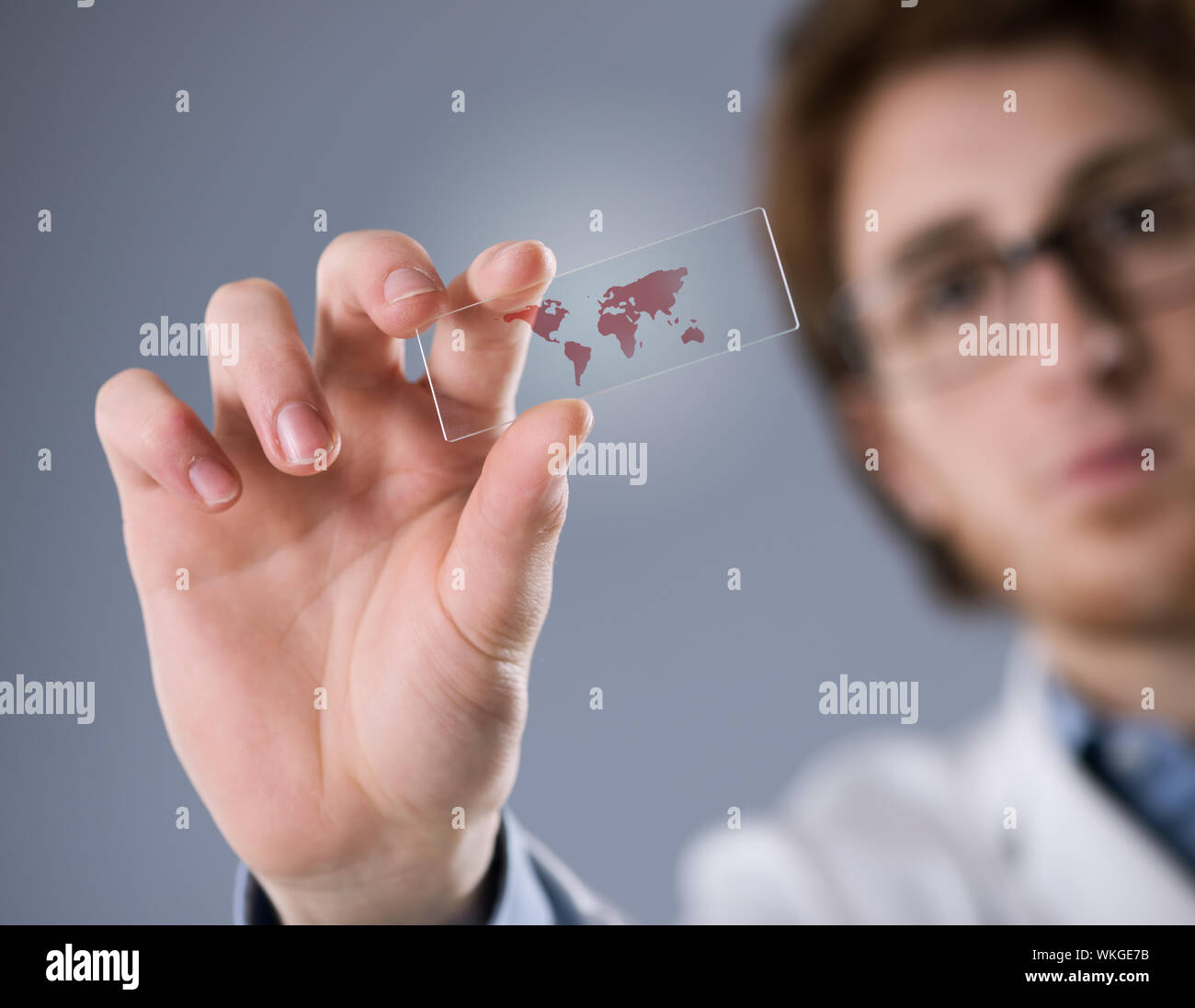 Researcher holding a microscope slide with world map Stock Photo - Alamy