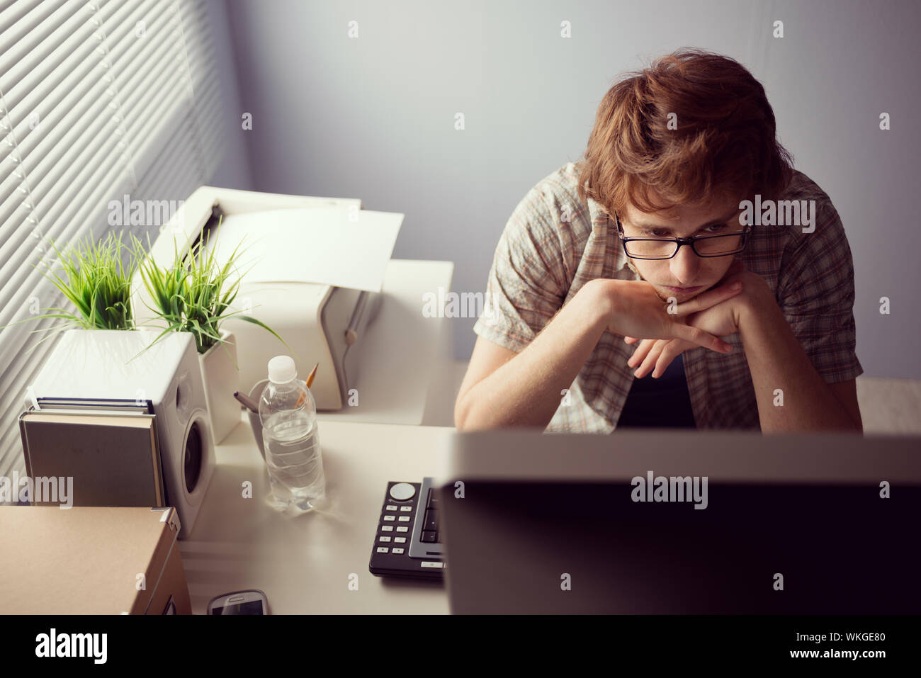 Young bored guy at office staring at computer screen Stock Photo - Alamy