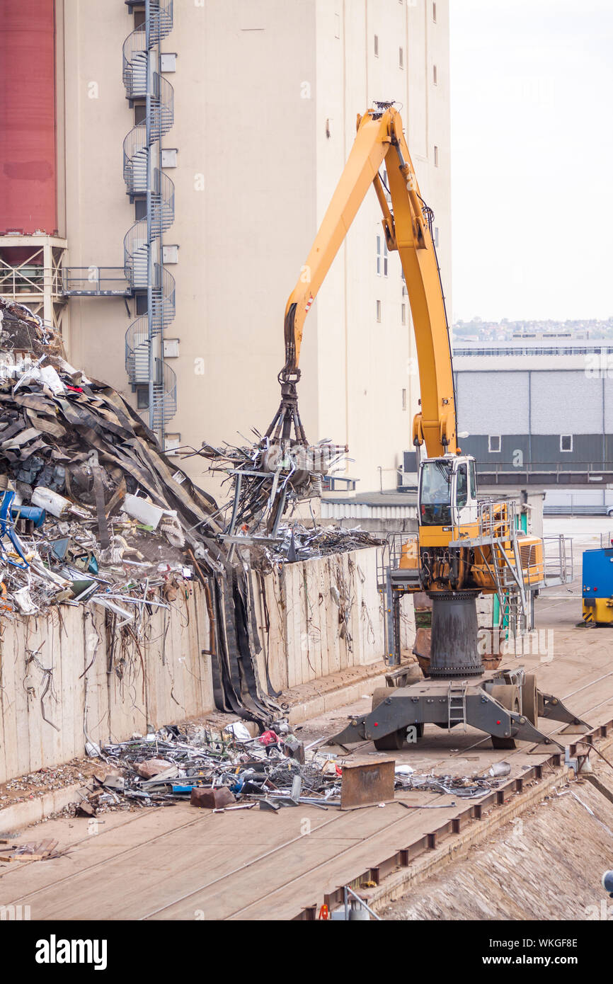Open barge being loaded or offloaded at a wharf on an urban waterway or ...