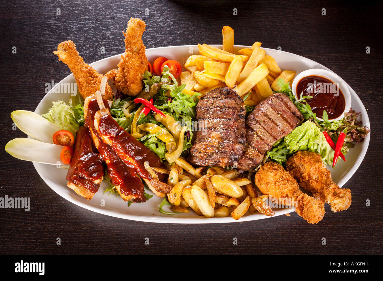 Wholesome platter of mixed meats including grilled steak, crispy ...