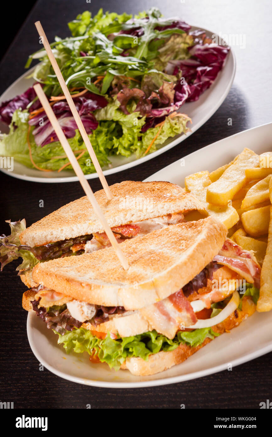 Club sandwich on toasted white bread with a meat filling served with ...